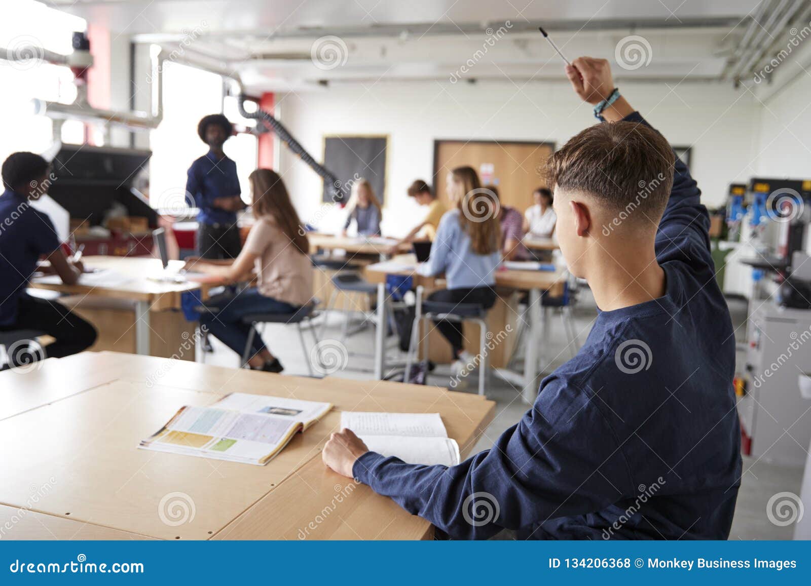 Male High School Student Asking Teacher Question in Design and ...