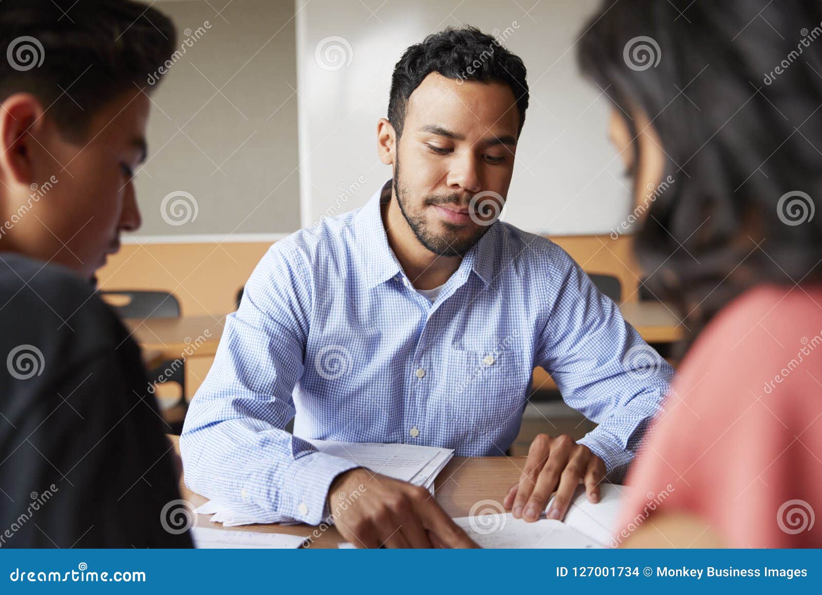 Male High School Tutor with Two Students at Desk in Seminar Stock Photo ...