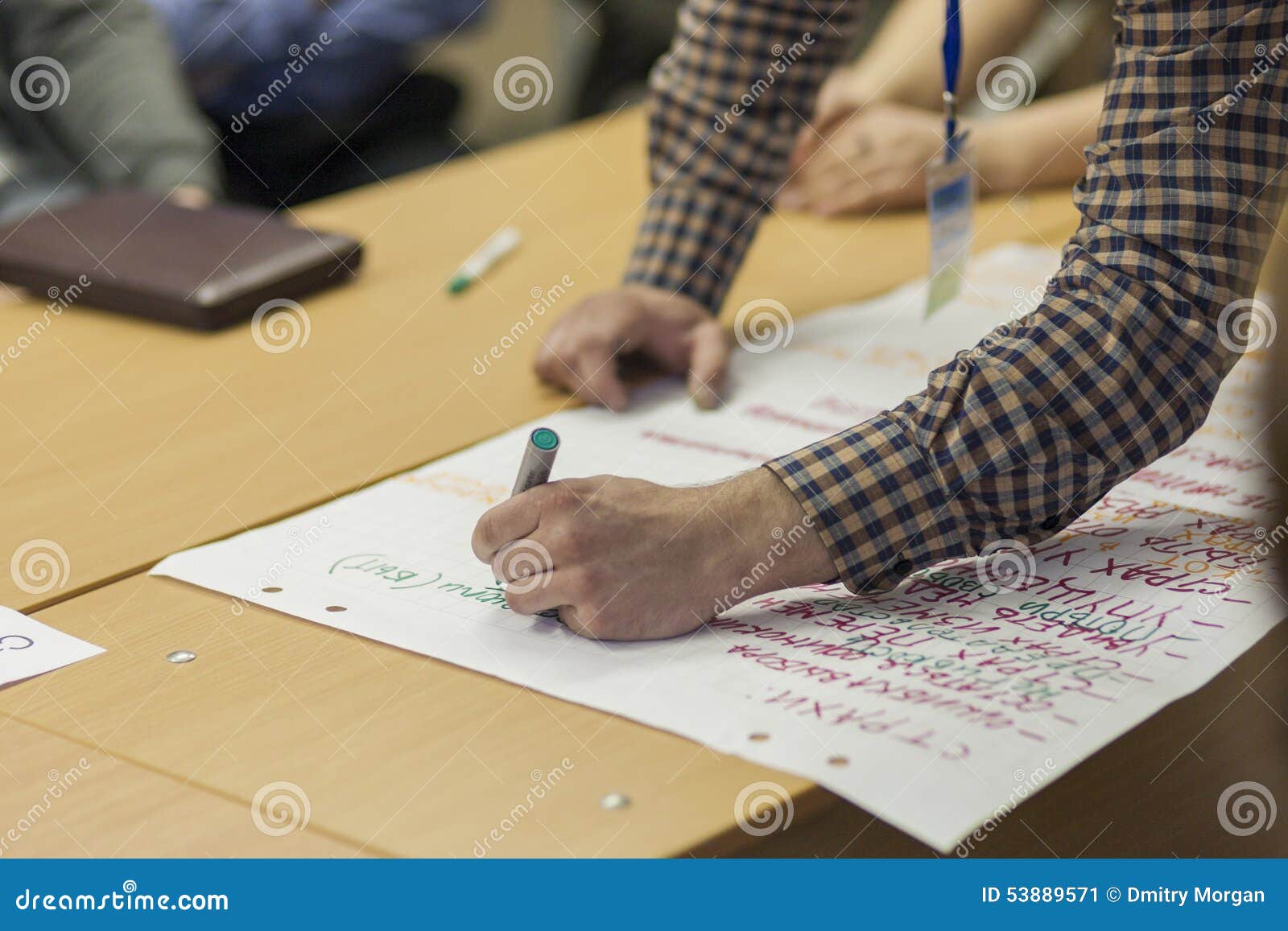 Male Host Writing on a Big Paper Sheet in Front of Group of People ...