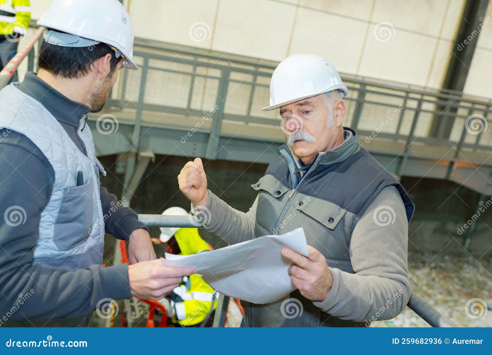 Male Industrial Workers in Discussion while Looking at Paperwork Stock ...