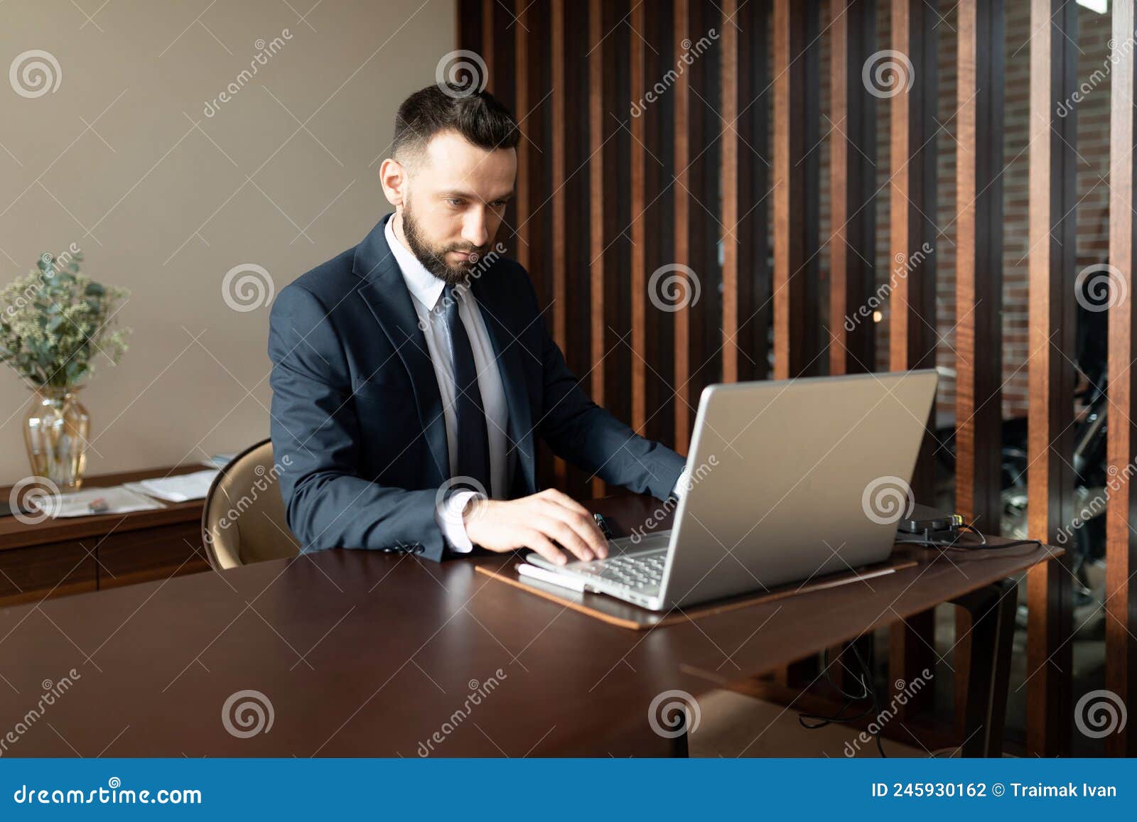 Male Insurance Agent in a Suit in the Office Working on a Laptop Stock ...