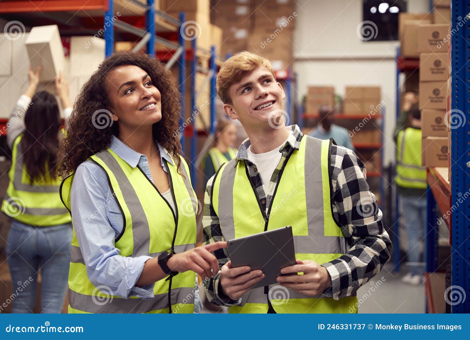 Male Intern with Team Leader Looking at Digital Tablet Inside Busy ...