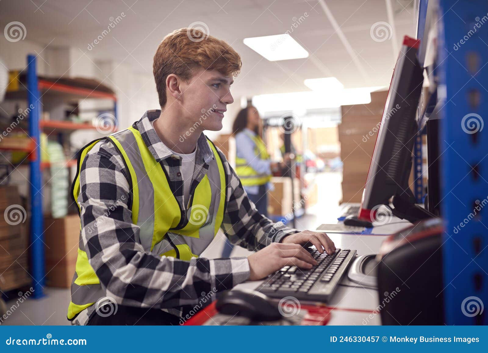 Male Intern Working in Busy Modern Warehouse on Computer Terminal Stock ...