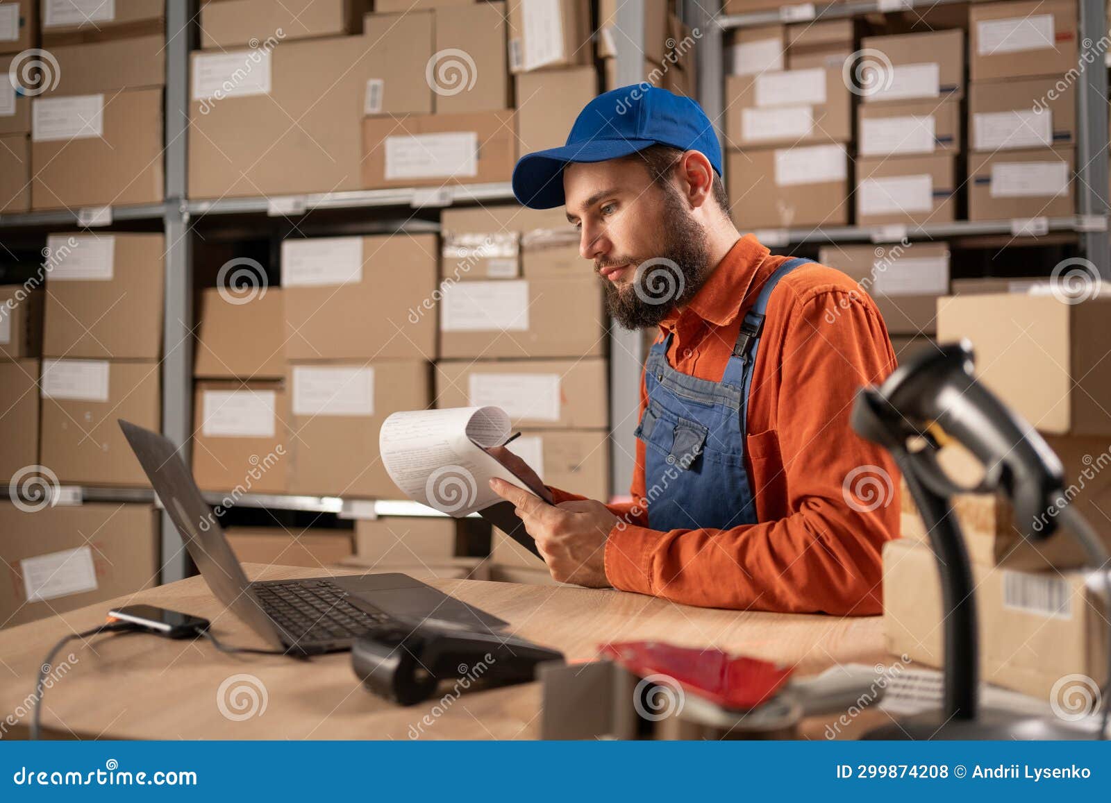 Male Inventory Manager Checking Inventory and Writing into an ...