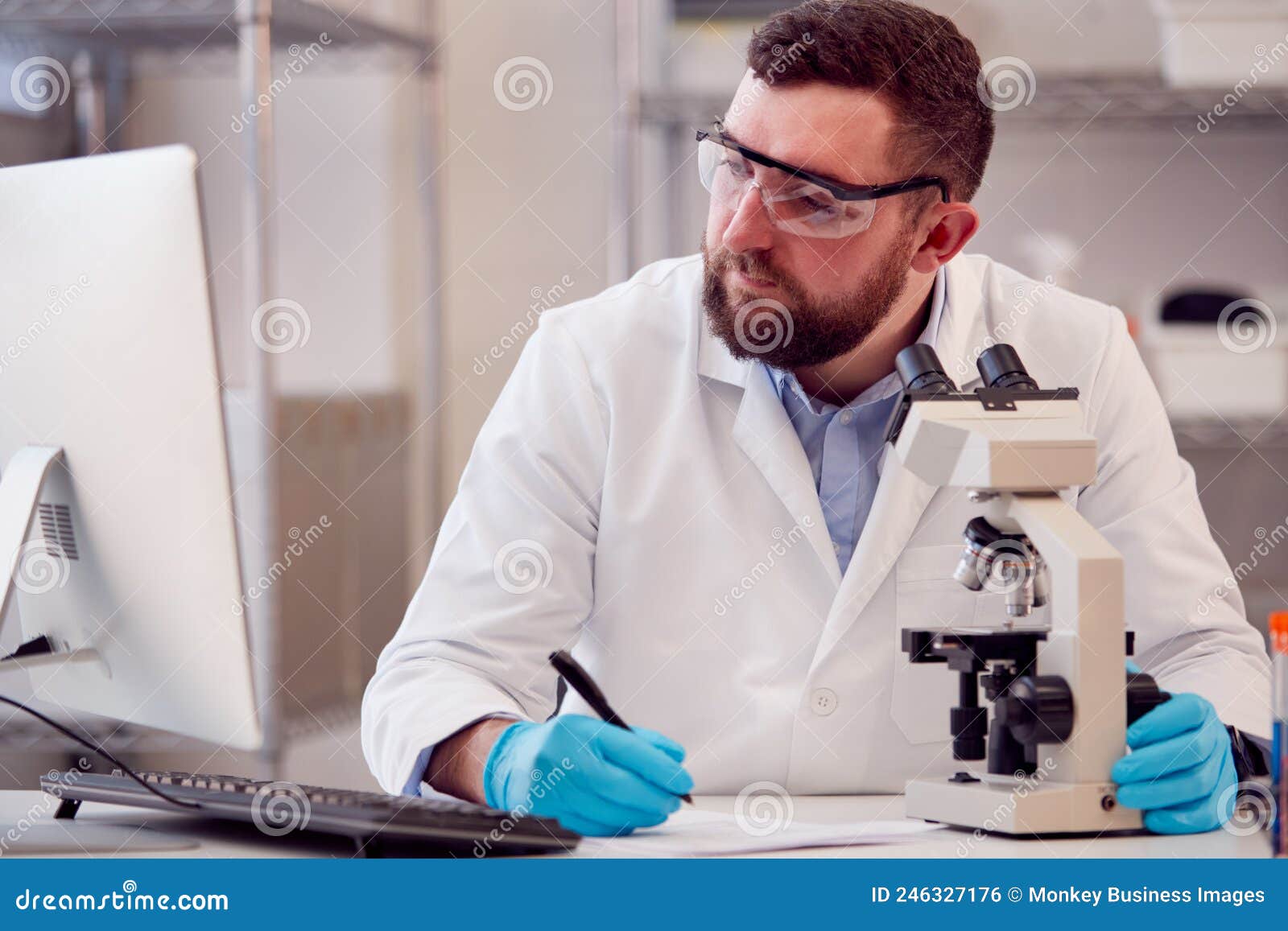 Male Lab Worker Wearing White Coat Recording Test Results on Computer ...