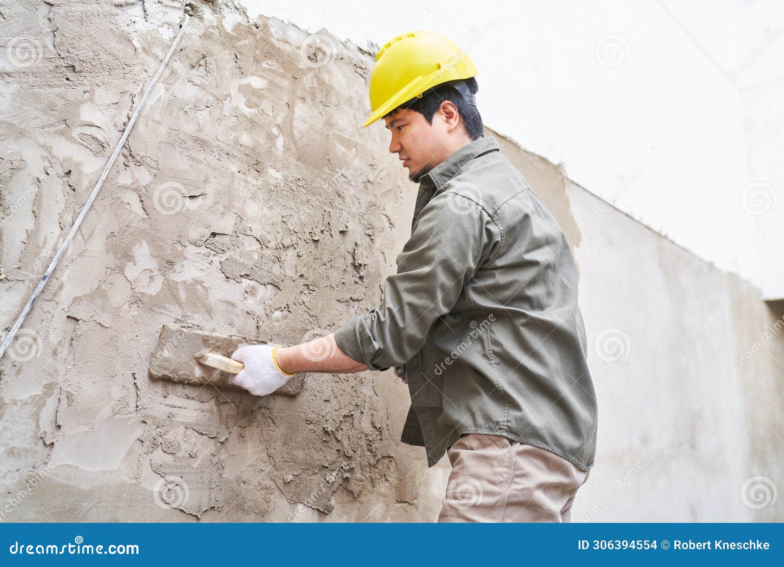 Young Male Labor Plastering on Wall with Mortar at Construction Site ...