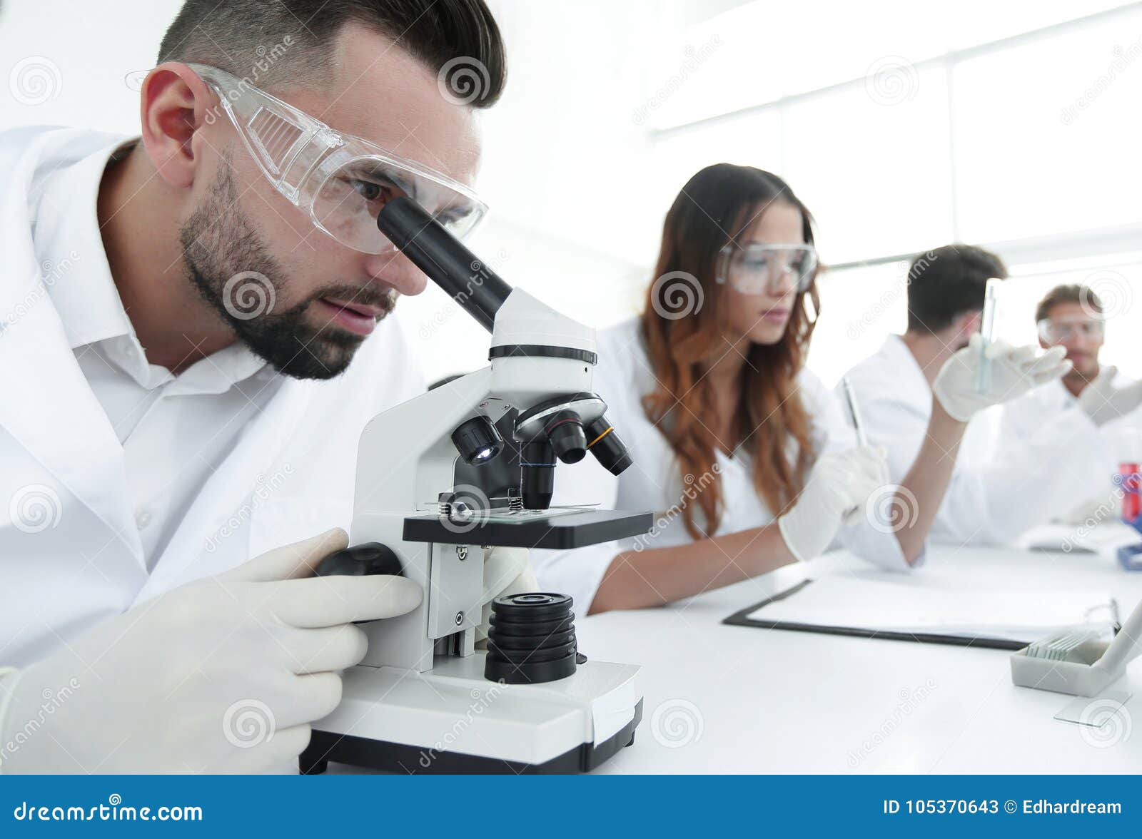 Male Laboratory Technician Looking at Samples in the Microscope Stock ...