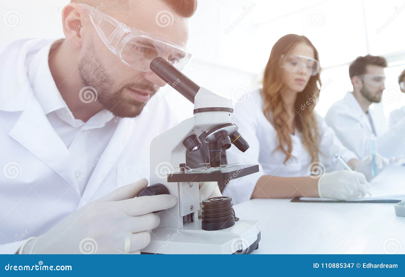 Male Laboratory Technician Looking at Samples in the Microscope Stock ...