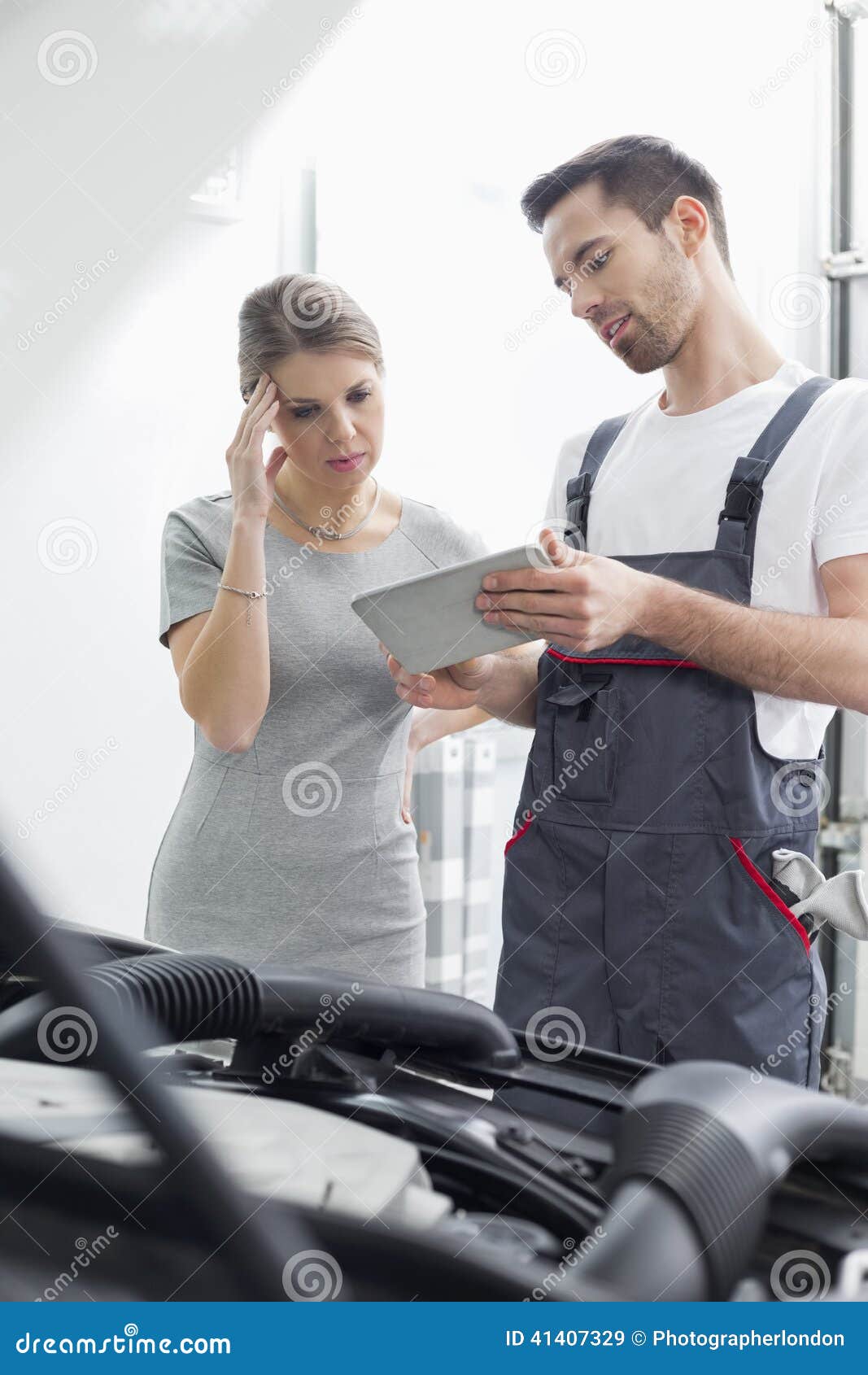 Male Maintenance Engineer Showing Digital Tablet To Worried Customer at ...