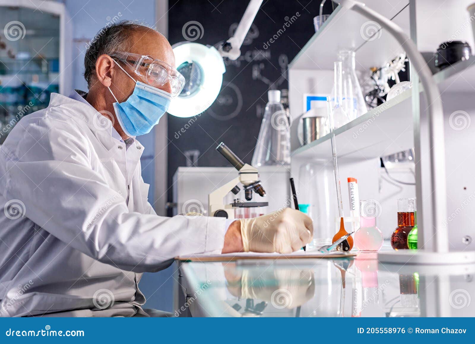 Male Microbiologist Make Notes while Analyzing the Test Tubes in Lab ...