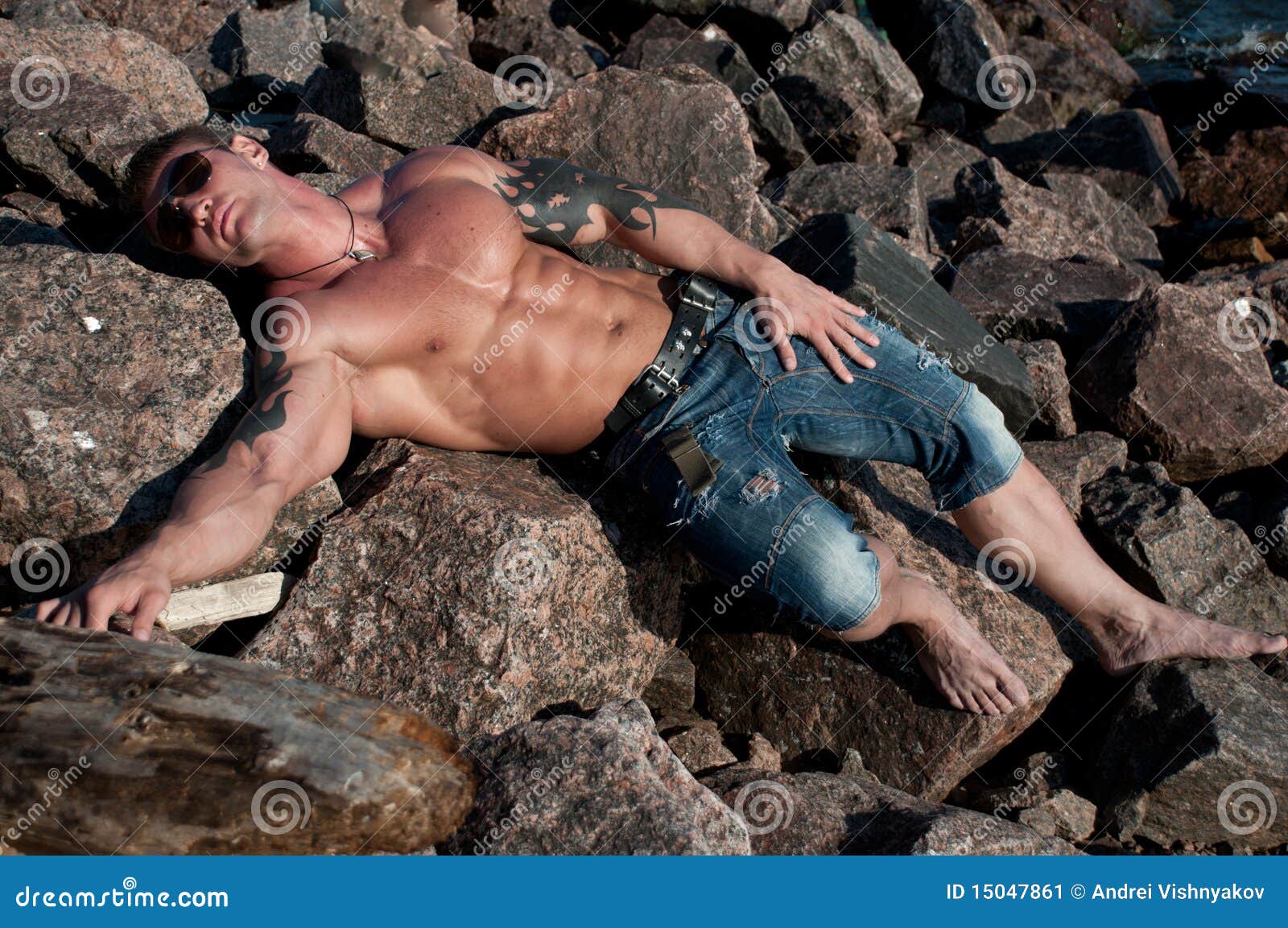 Male model on the rocks stock image. Image of muscle - 15047861
