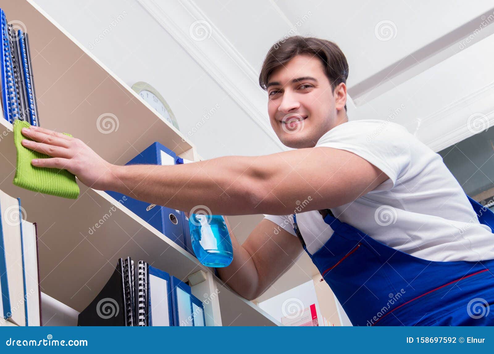 Male Office Cleaner Cleaning Shelves in Office Stock Photo - Image of ...