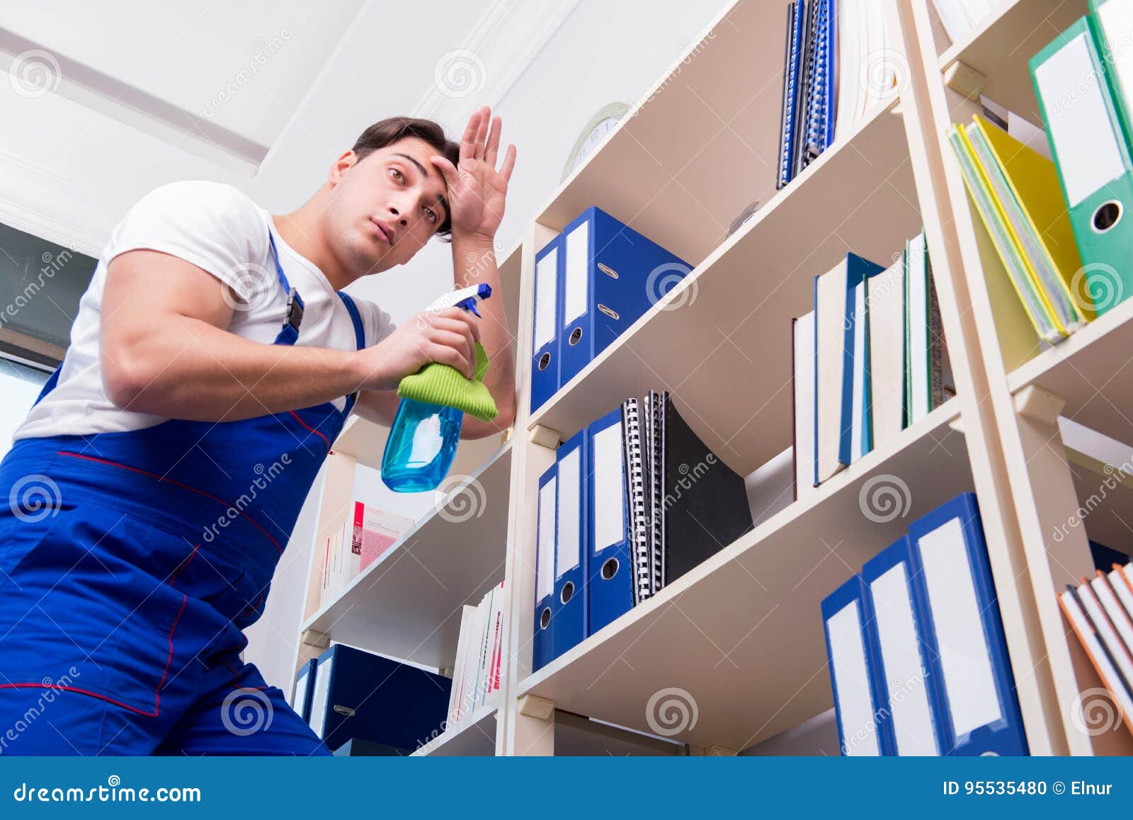 The Male Office Cleaner Cleaning Shelves in Office Stock Photo - Image ...