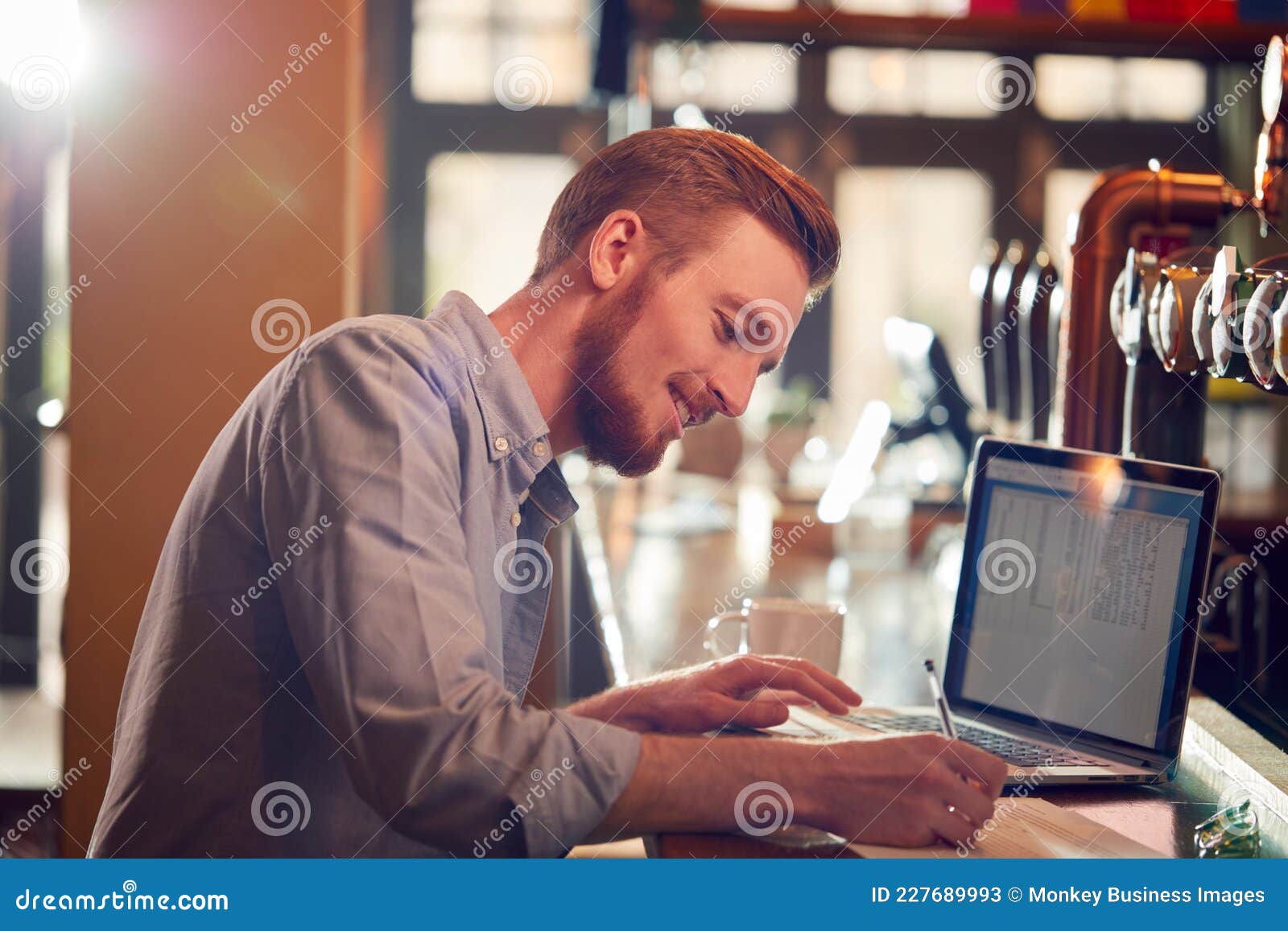 Male Owner or Manager of Bar Working on Laptop on Counter Stock Image ...