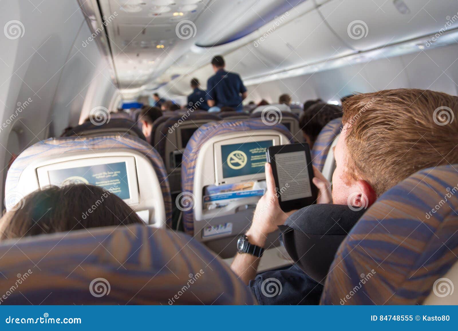 Male Passenger Reading E-book on Electronic Reader on Airplane ...