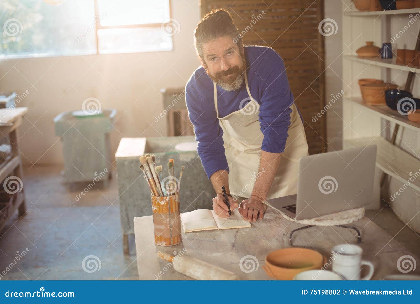 Male Potter Writing on a Book Stock Photo - Image of pottery, laptop ...