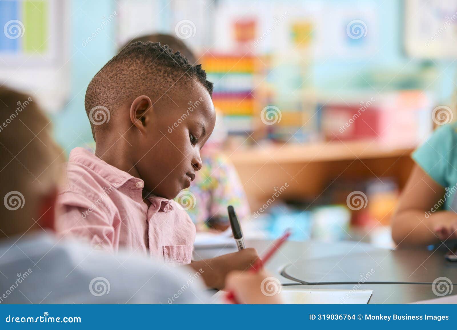 Male Primary or Elementary School Student at Desk in Classroom Stock ...