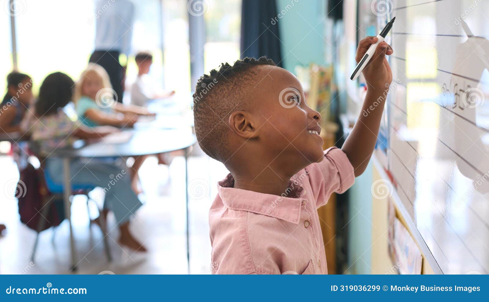 Male Primary or Elementary School Student Writing on Whiteboard in ...