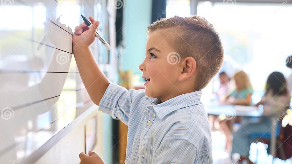 Male Primary or Elementary School Student Writing on Whiteboard in ...