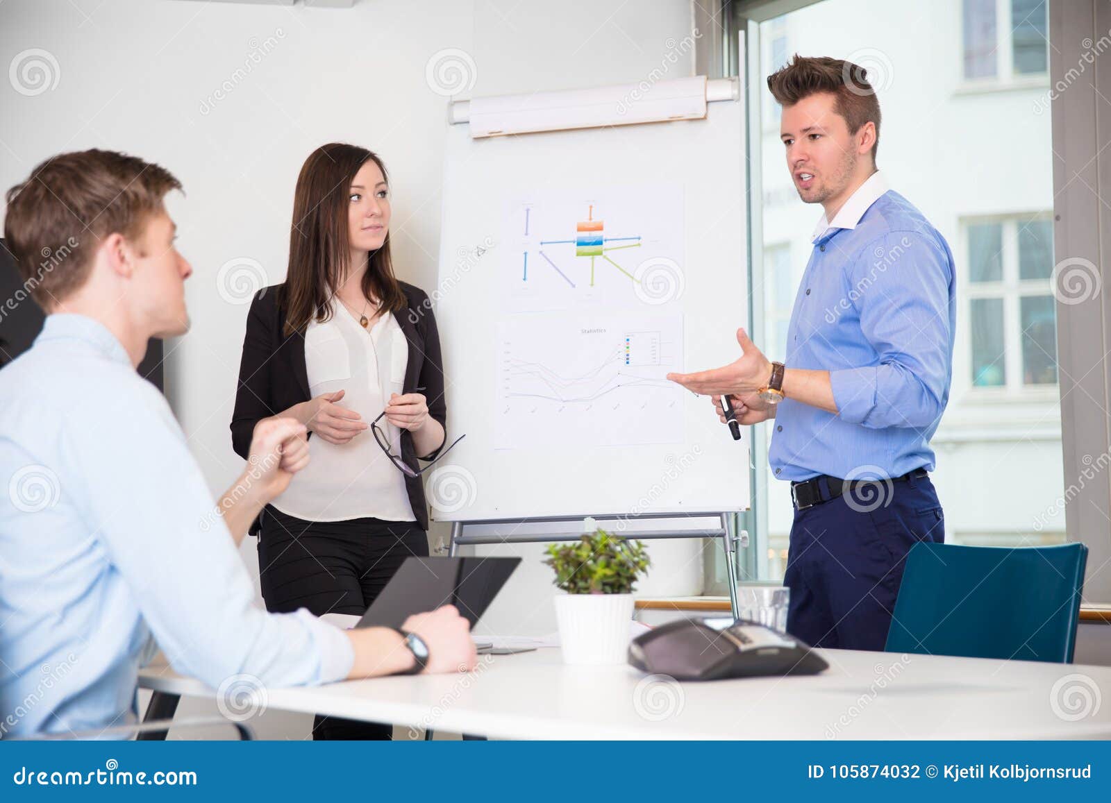 Male Professional Explaining Chart To Coworkers in Office Stock Photo ...