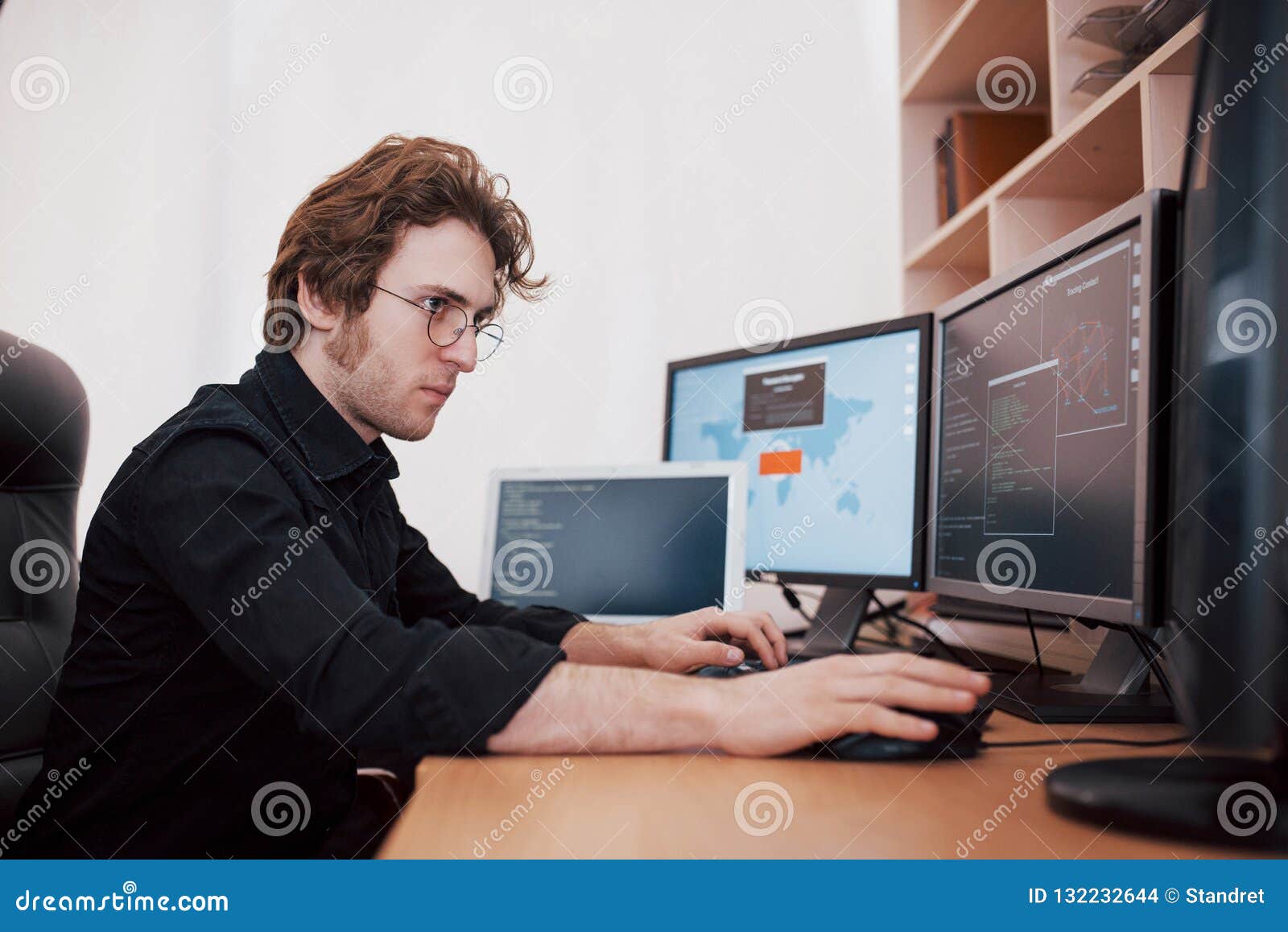 Male Programmer Working on Desktop Computer with Many Monitors at ... Male Programmer Working on Desktop Computer with Many Monitors at ...