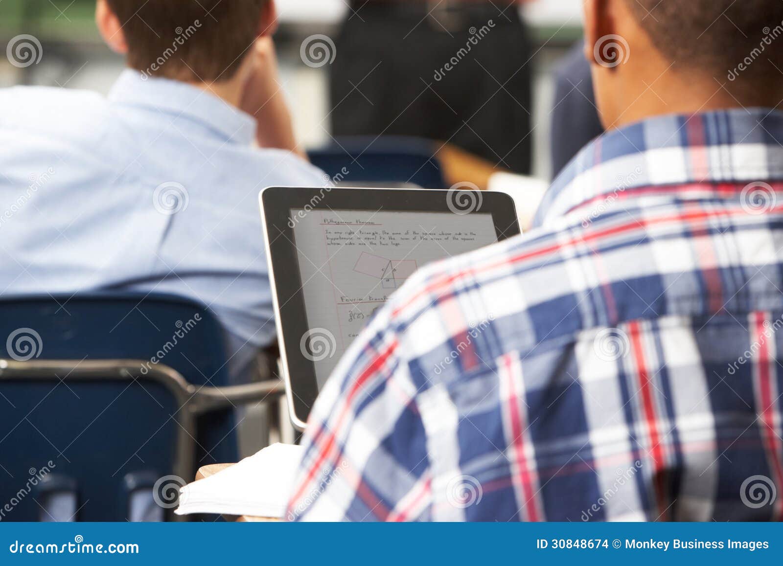 Male Pupil Using Digital Tablet in Classroom Stock Photo - Image of ...