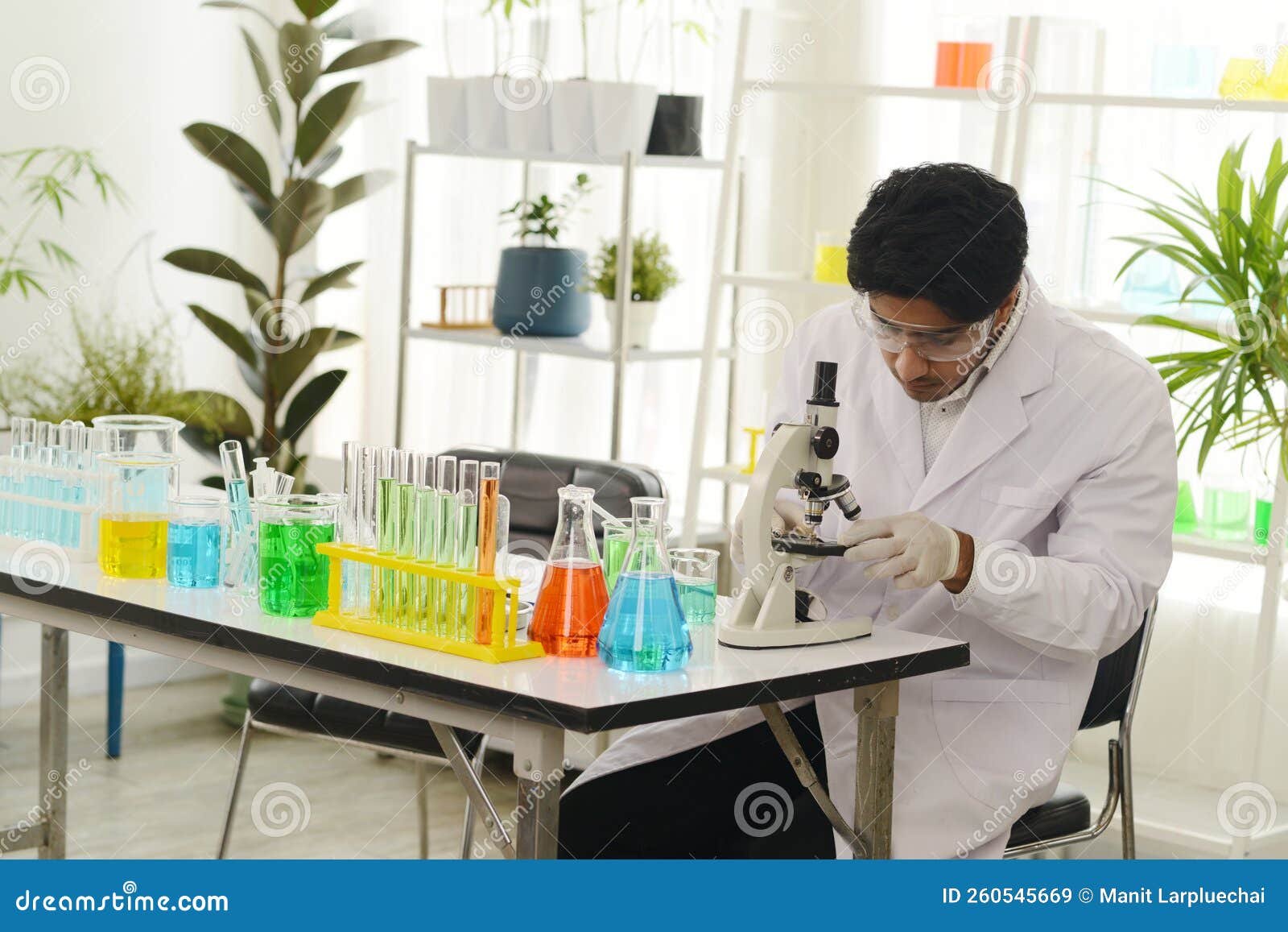Male Research Medical Scientist Working with a Microscope in a ...