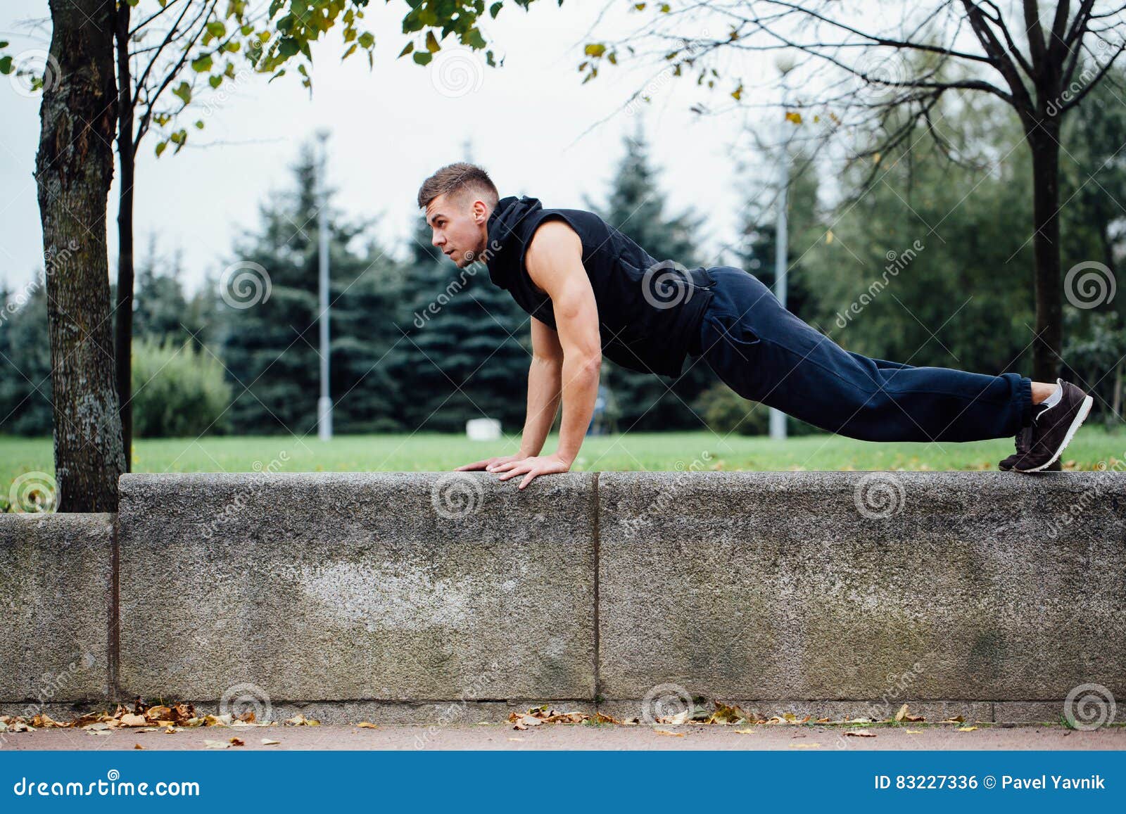 Male Runner Doing Exercise, Workout in the Fall Park. Push Ups with ...