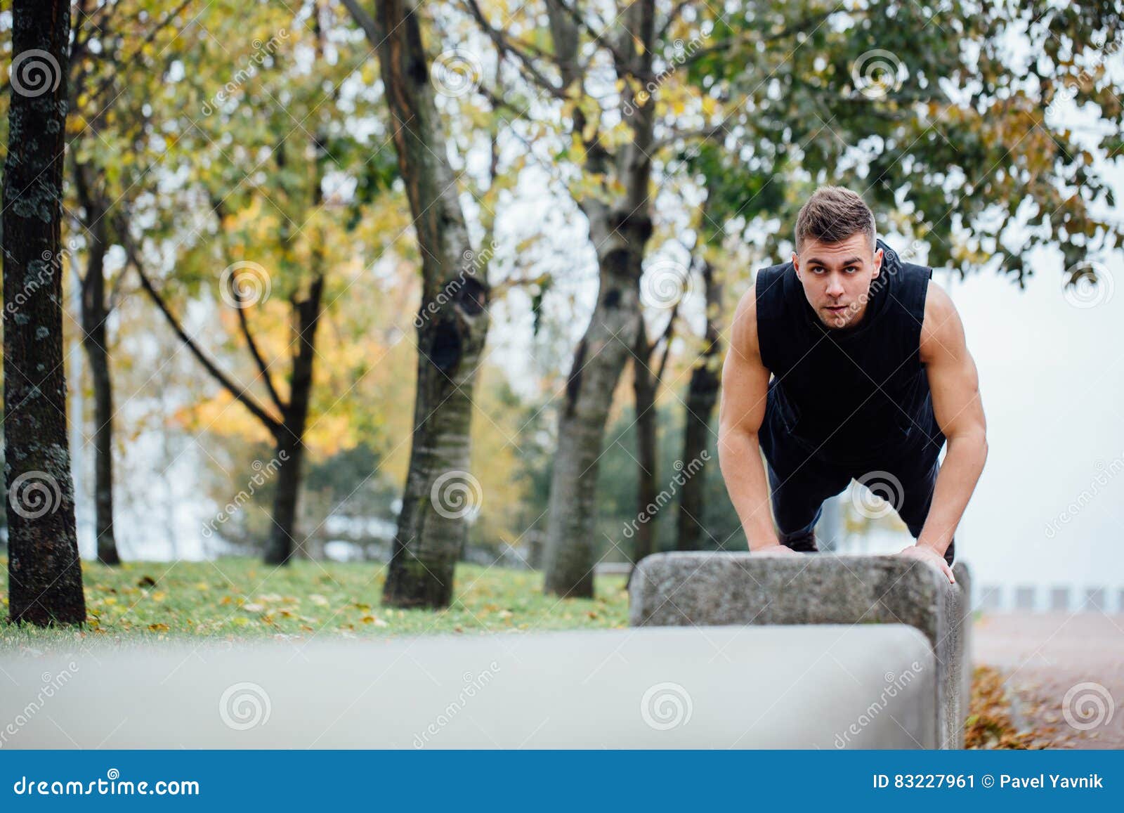 Male Runner Doing Exercise, Workout in the Fall Park. Push Ups with ...