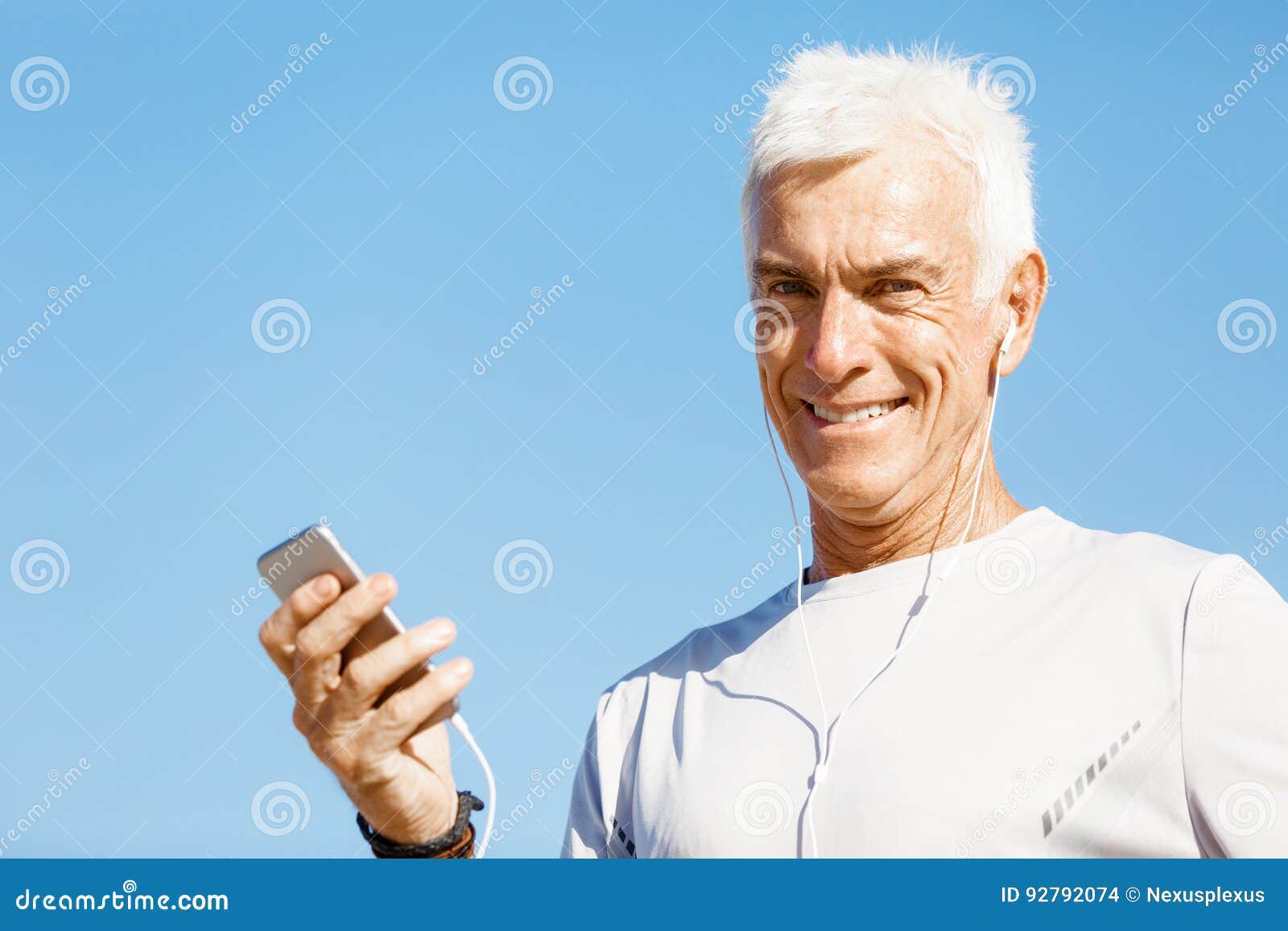 Male Runner with His Mobile Smart Phone Standing Outdoors Stock Photo ...