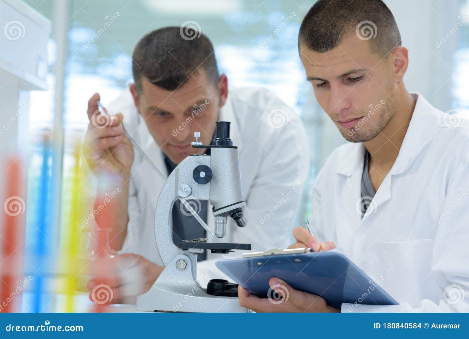Male Scientists with Clipboard and Microscope in Lab Stock Photo ...