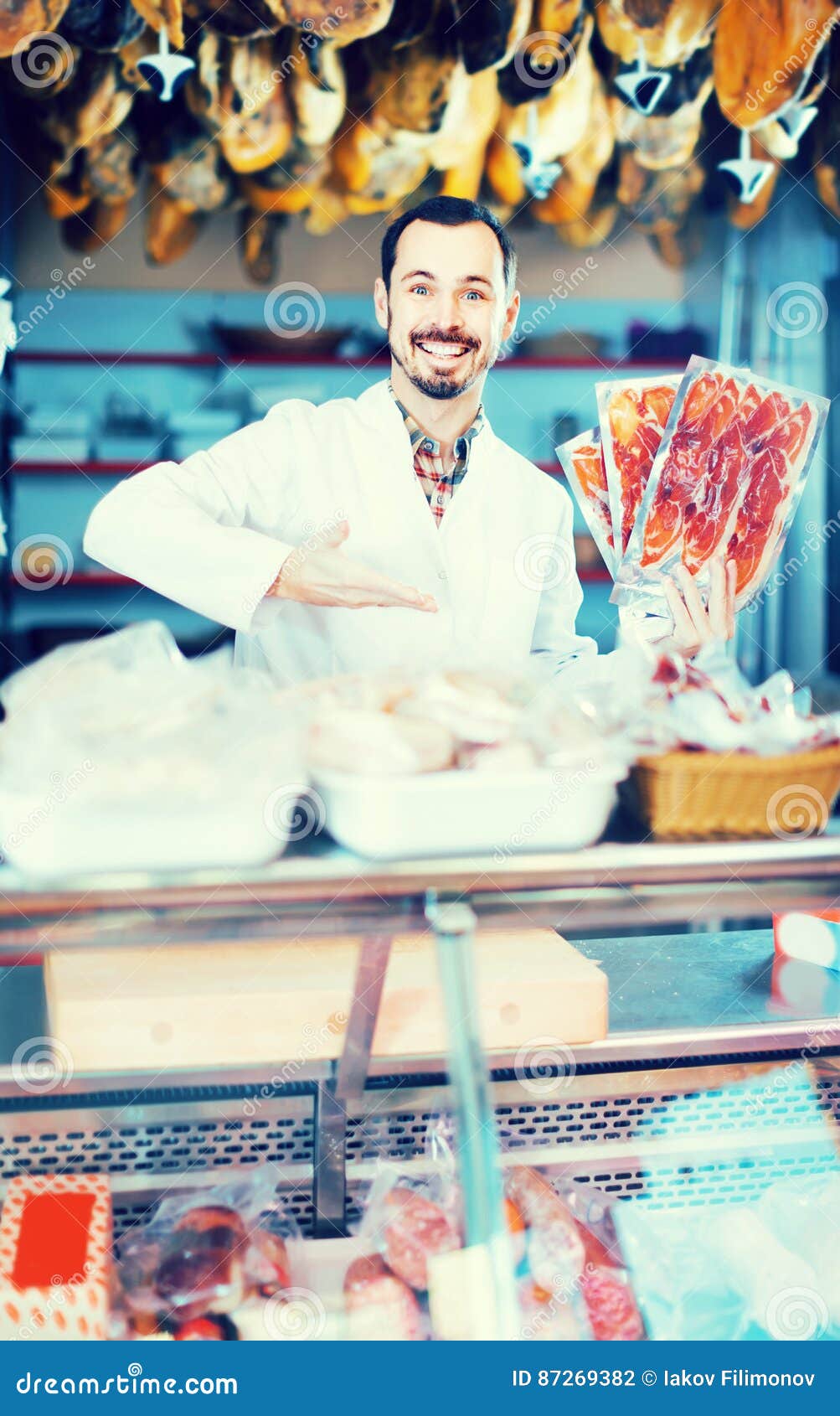 Male Shop Assistant Demonstrating Sliced Bacon In Butcher’s Sh Stock