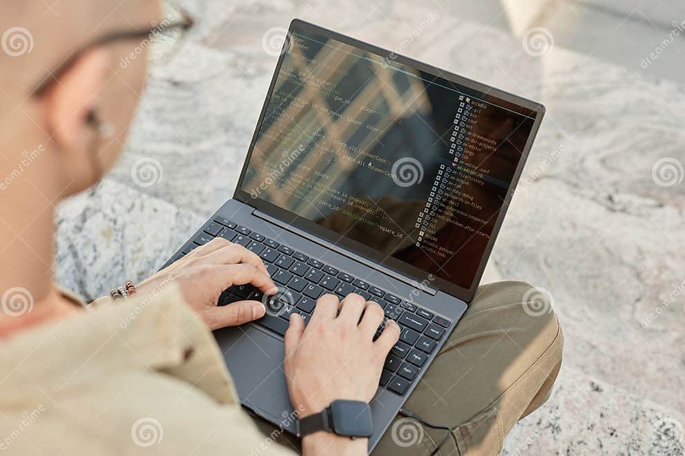 Male Software Developer Writing Code on Laptop while Sitting on Steps ...