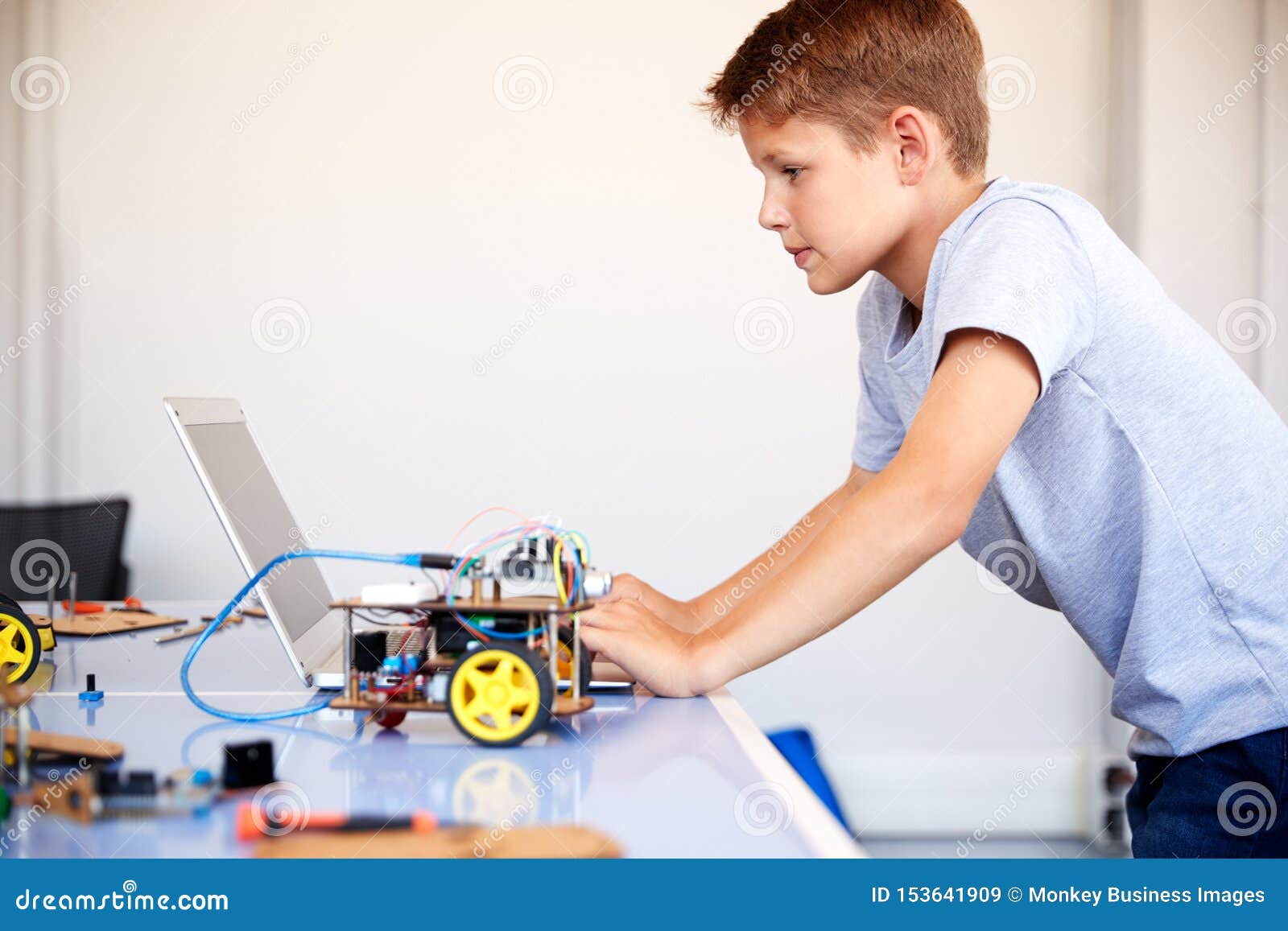 Male Student Building and Programing Robot Vehicle in School Computer ...