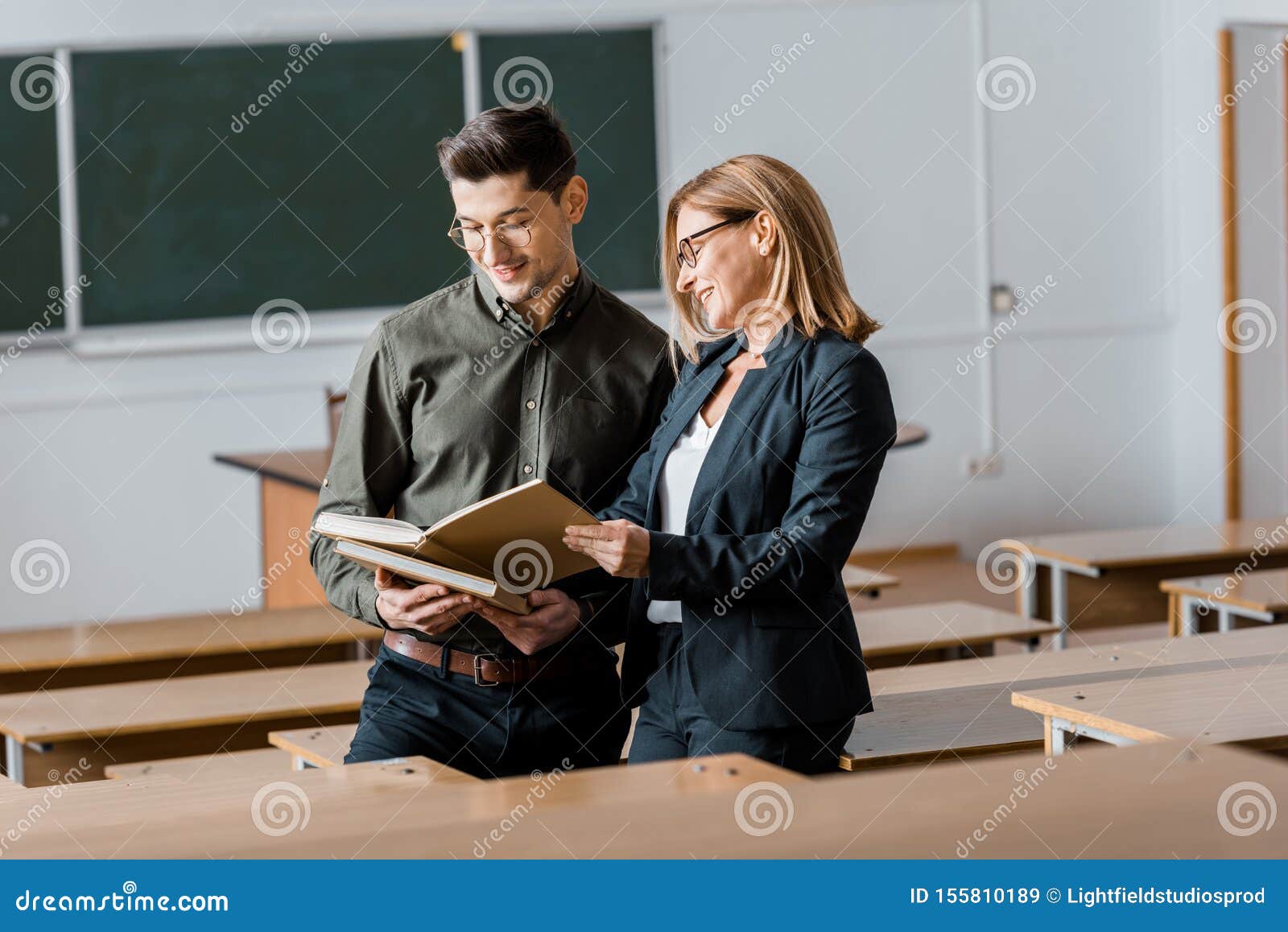 Male Student and Female Teacher in Formal Wear Looking at University ... Male Student and Female Teacher in Formal Wear Looking at University ...