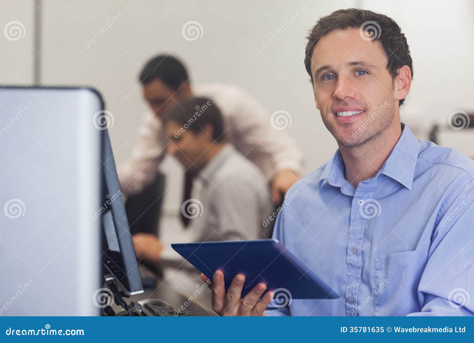 Male Student Holding a Tablet Sitting in Front of Computer Stock Image ...