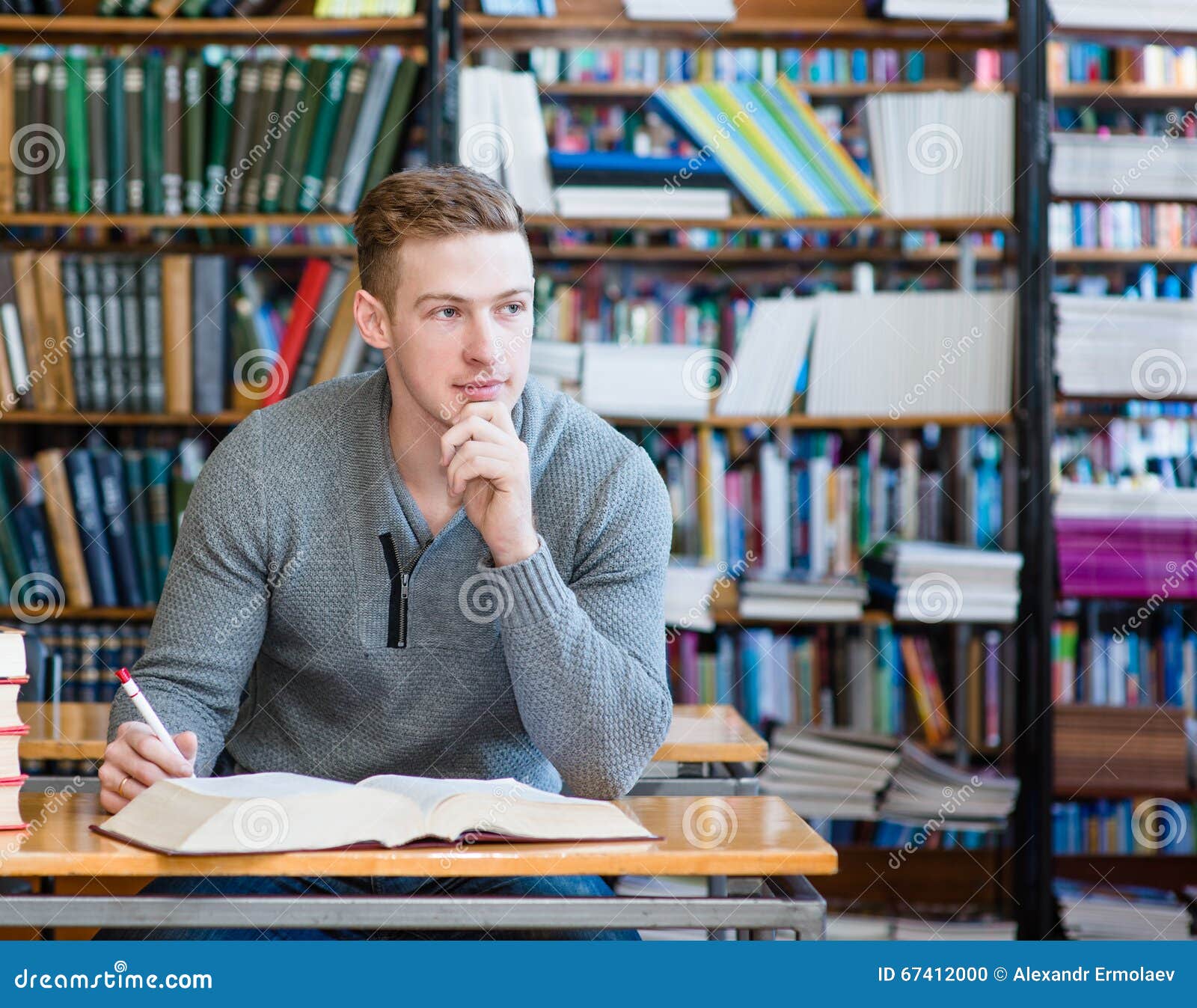 Male Student with Open Book Working in a Library Stock Photo - Image of ...