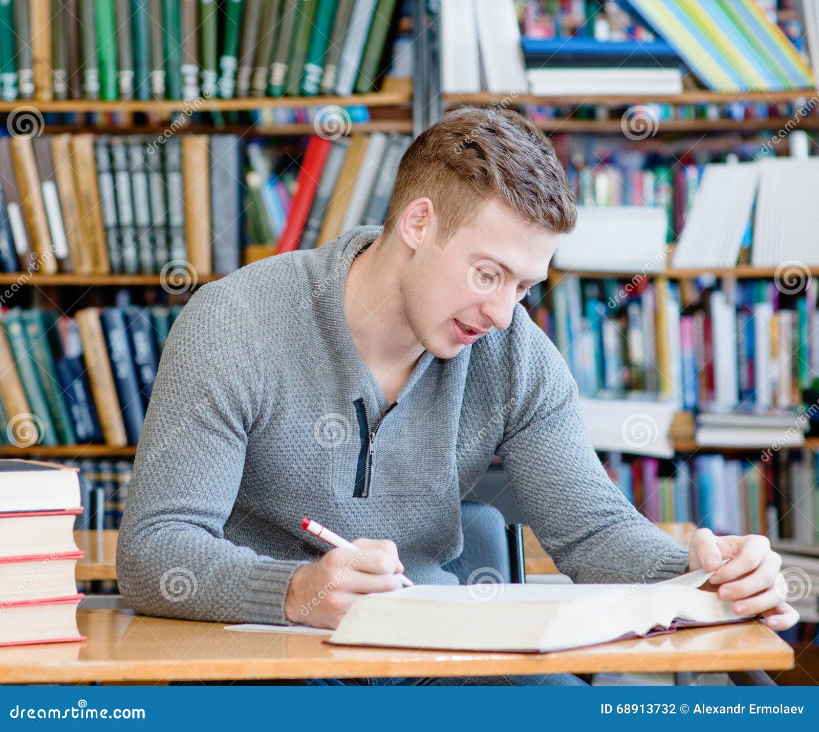 Male Student with Open Book Working in a Library Stock Photo - Image of ...