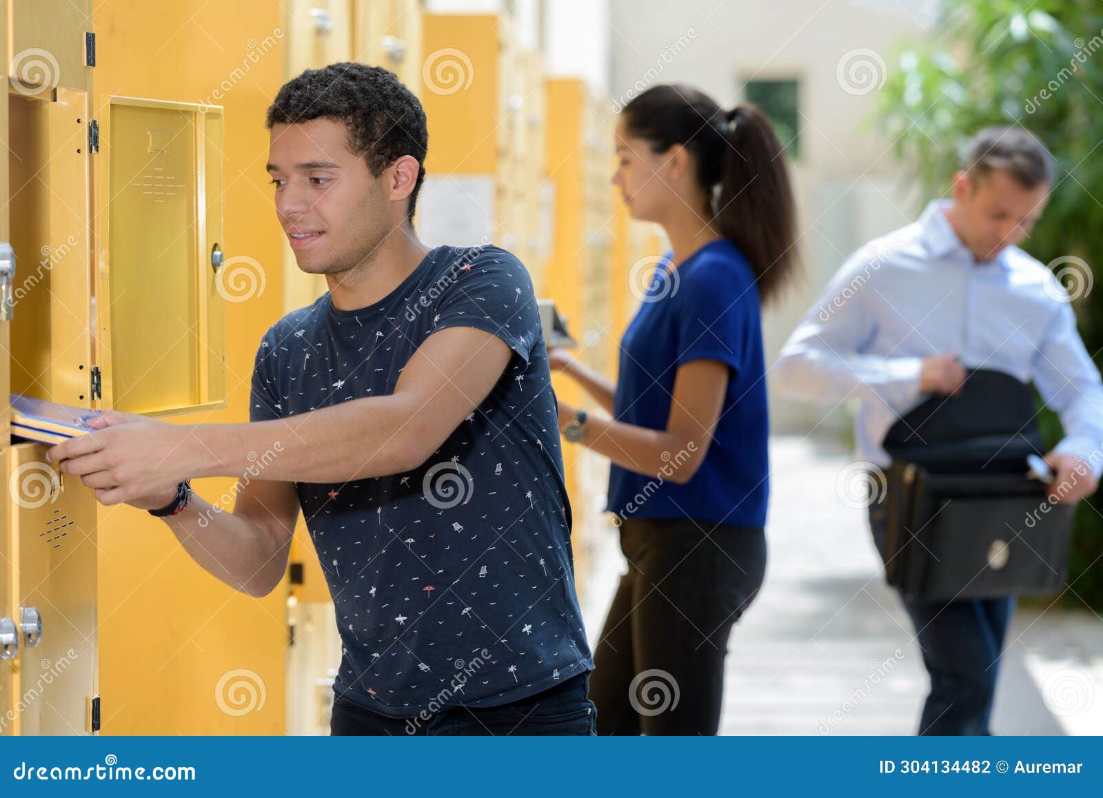 Male Student Putting Books in Locker Stock Photo - Image of holding ...