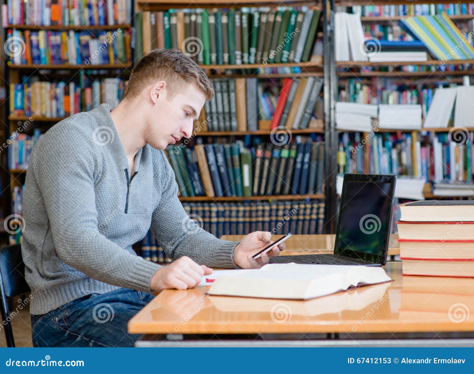 Male Student Texting on the Phone in the University Library Stock Image ...