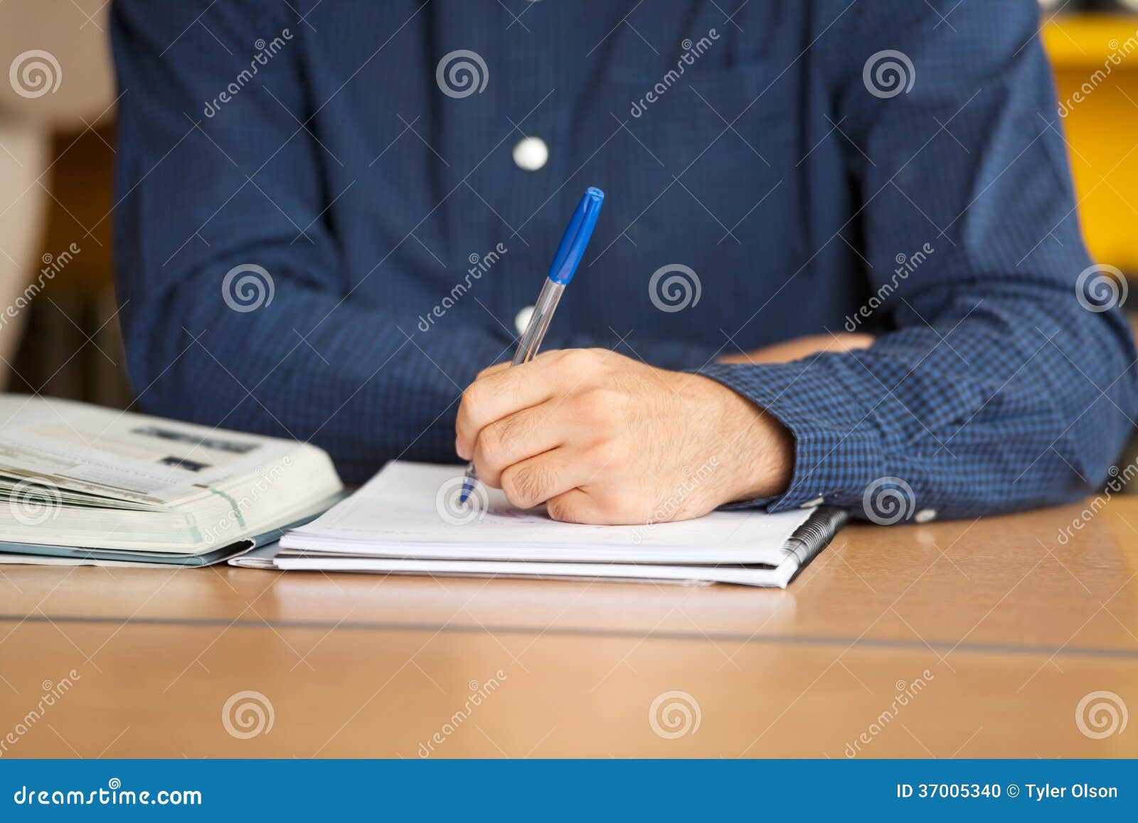 Male Student Writing in Book at Library Stock Photo - Image of ...