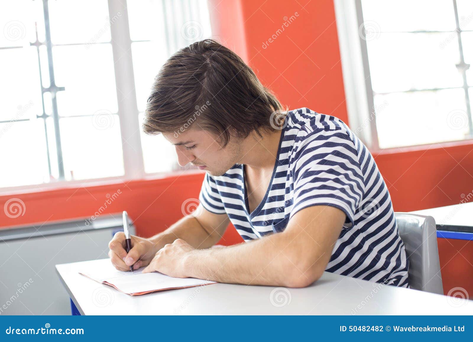 Male Student Writing Notes in Classroom Stock Photo - Image of school ...