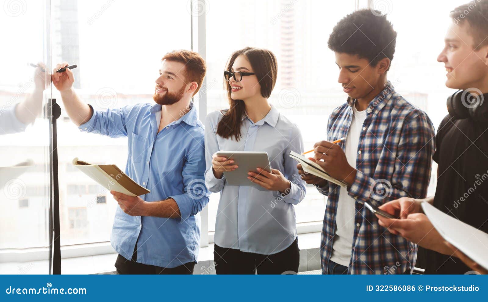 Male Student Writing on Whiteboard in Classroom, Classmates Taking ...