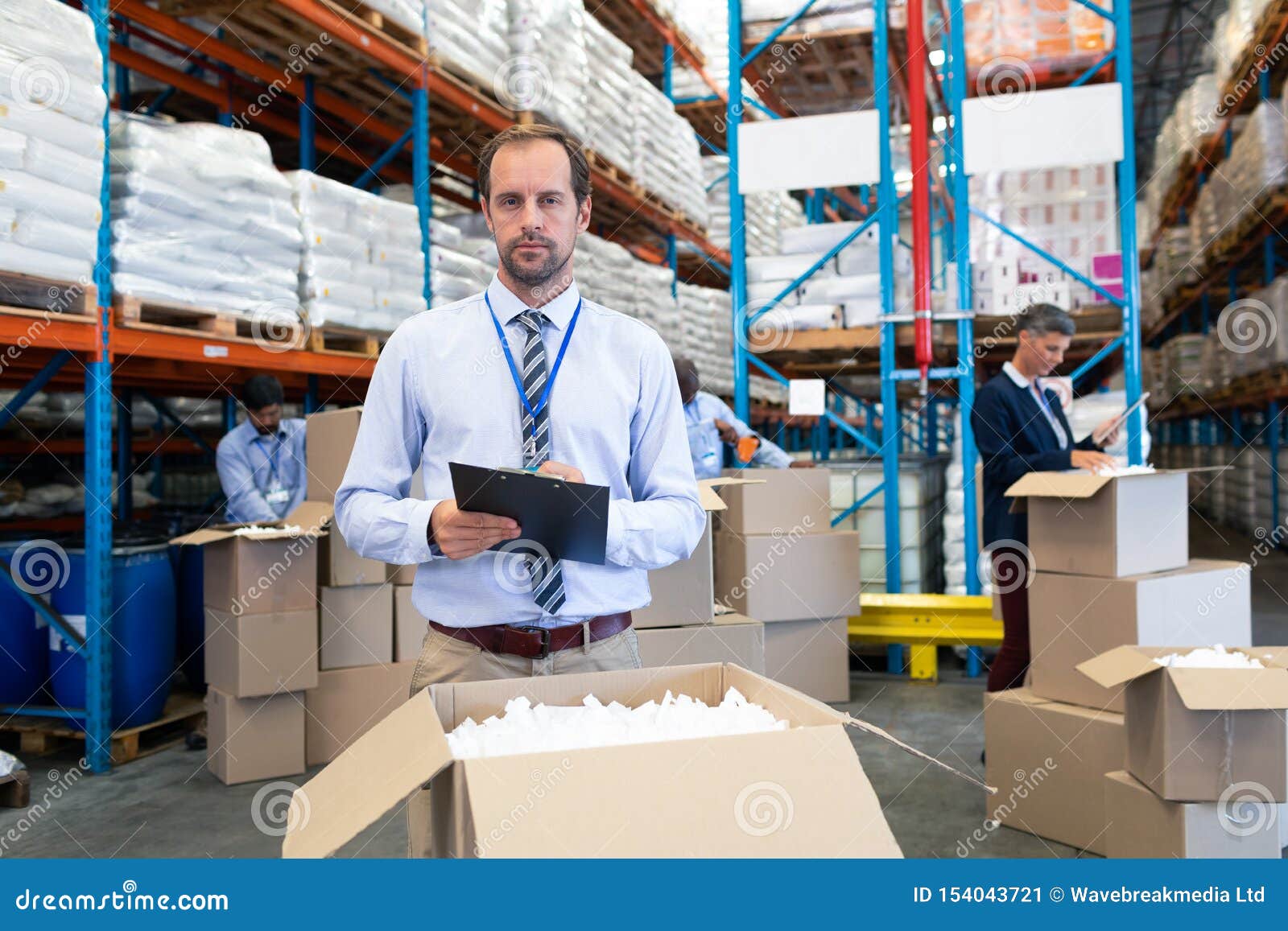 Male Supervisor Looking at Camera while Checking Stocks in Warehouse ...
