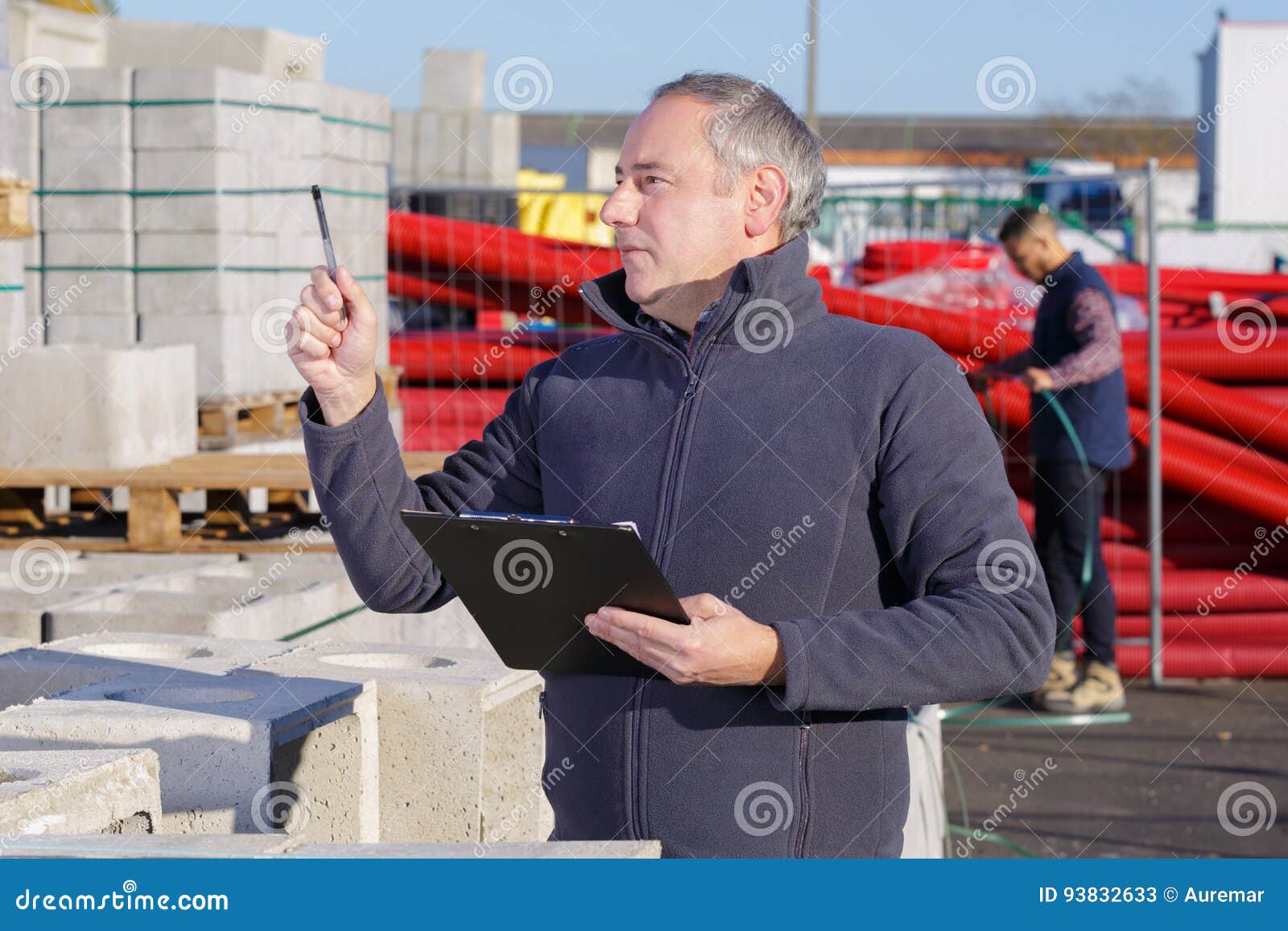 Male Supervisor Stock Taking Outside Warehouse Against Stack Wood Stock ...