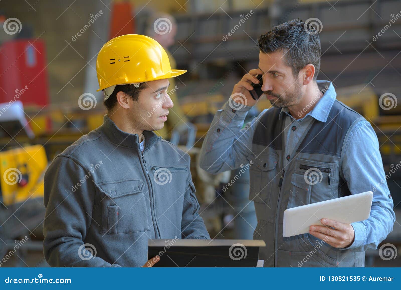 Male Supervisor Talking on Mobile Phone with Worker at Industry Stock ...