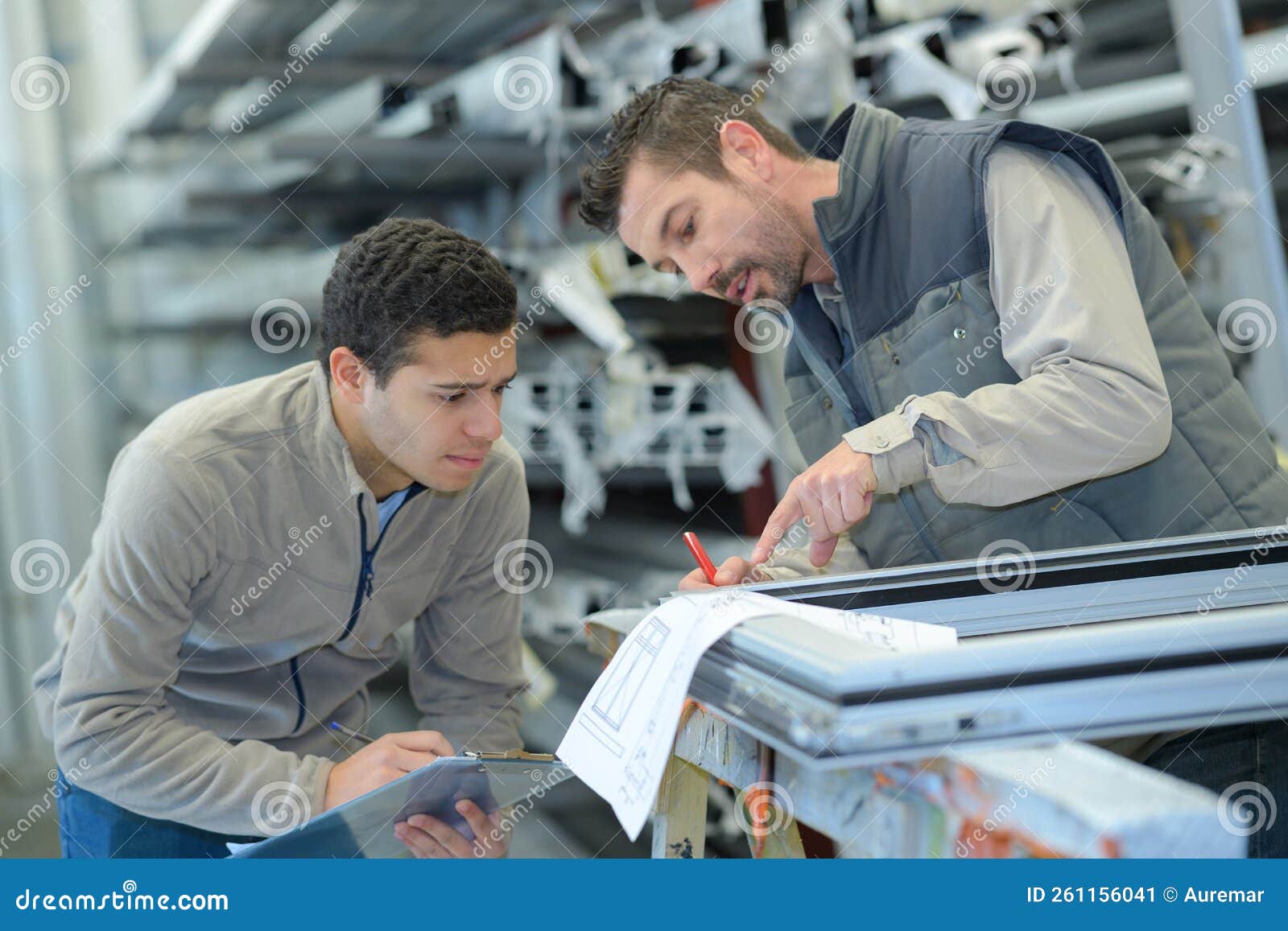 Male Supervisor with Worker Discussing Over Blueprints in Industry ...