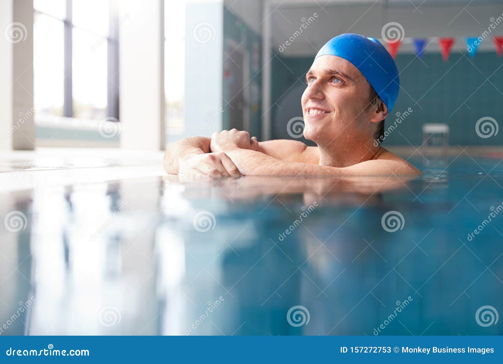 Male Swimmer Wearing Hat And Goggles Training In Swimming Pool Stock