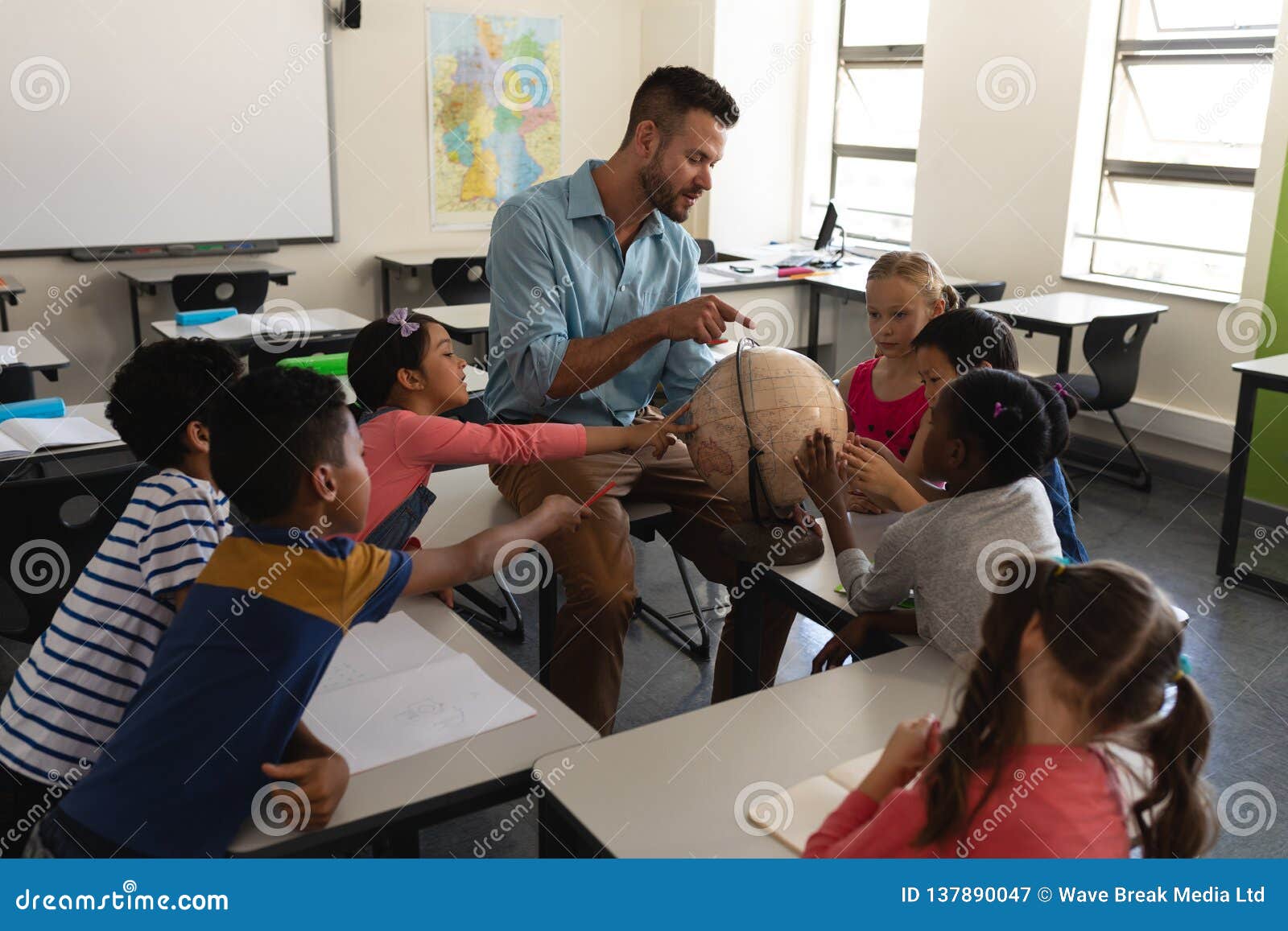 Male Teacher Teaching His Kids about Geography by Using Globe in ...