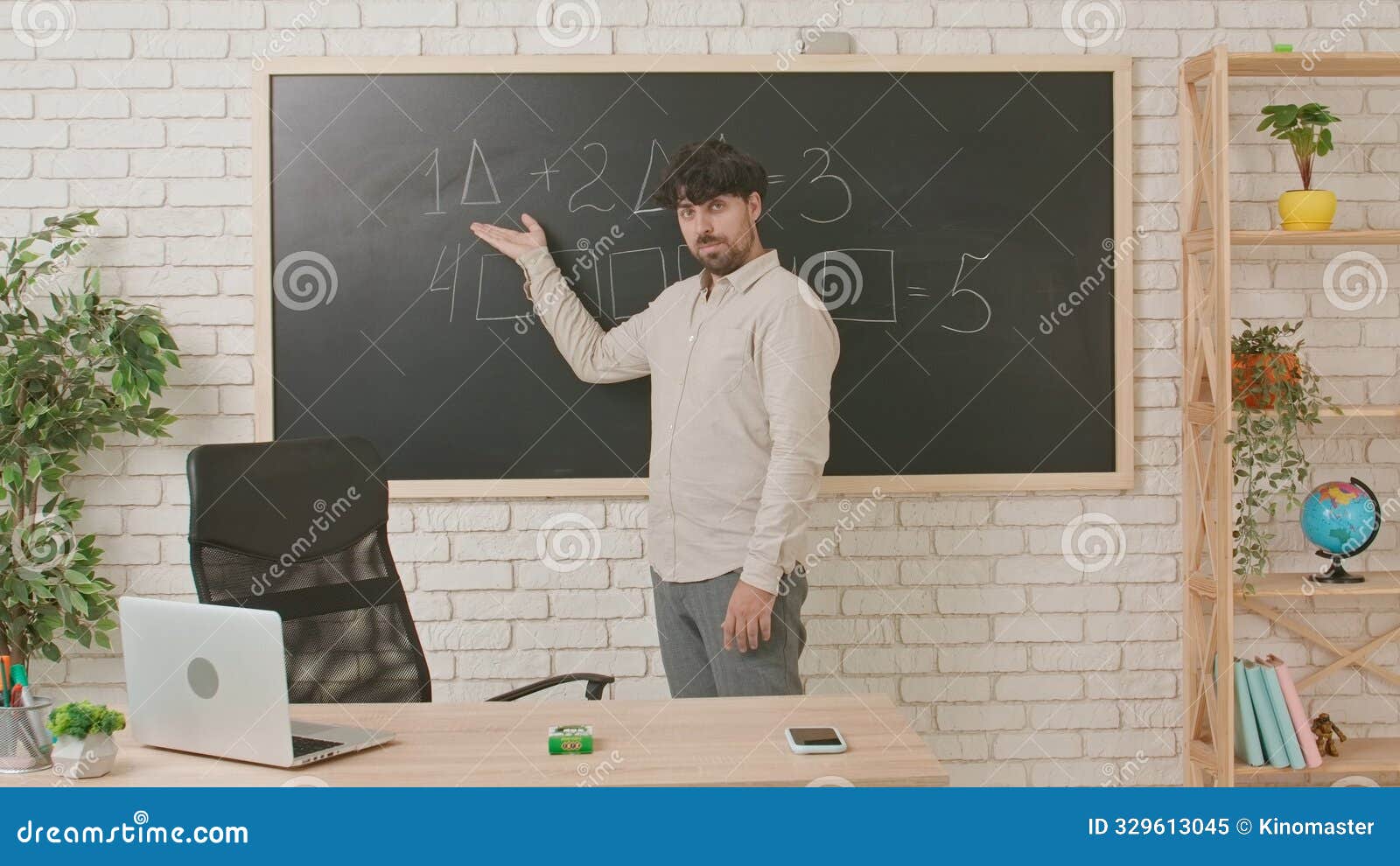 A Male Teacher is Teaching a Math Class and Explaining Equations ...